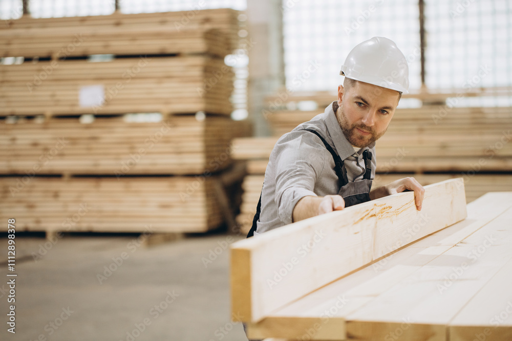 Carpenter working with wooden planks in timber warehouse for modular ...