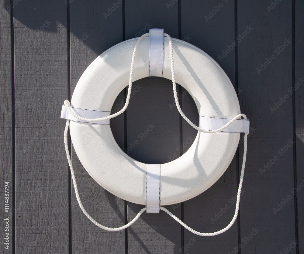 Bright white life saver on gray wall with shadows for safety and rescue ...