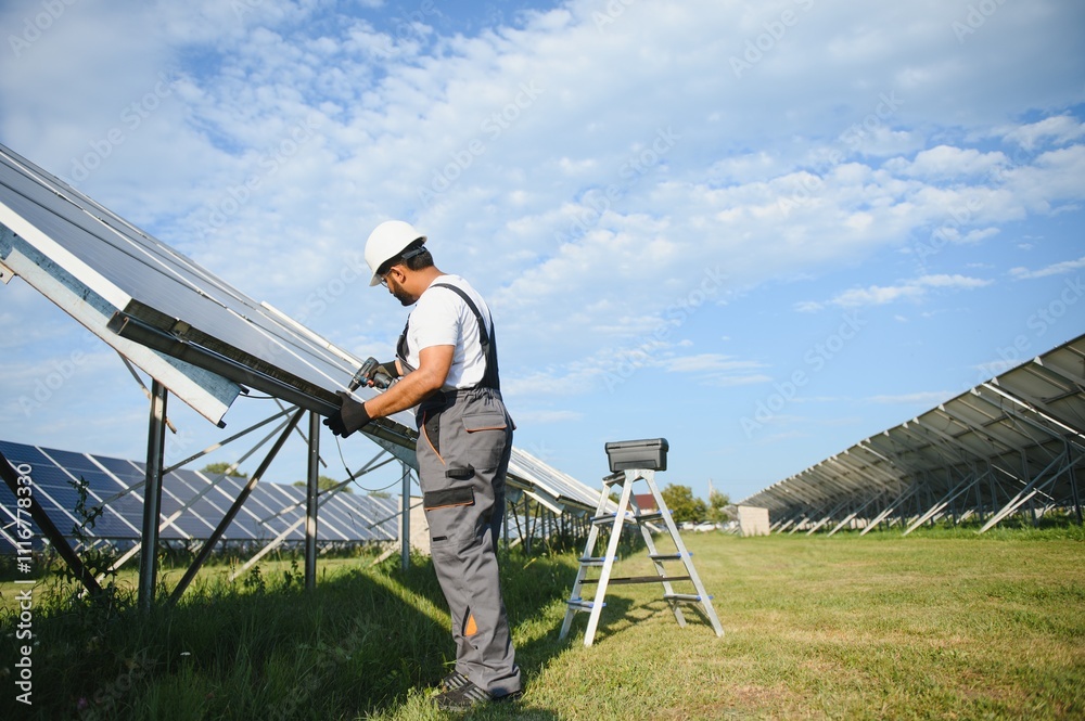 Indian man in uniform on solar farm. Competent energy engineer ...