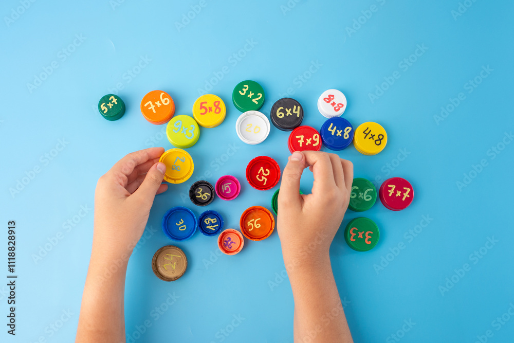 Foto de Stock Math learning game with child hands sorting colorful caps ...