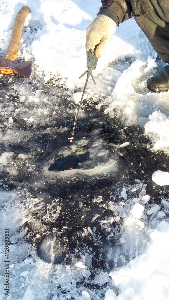 a person ice fishing fishing rod water is in the hole types of rods and ...