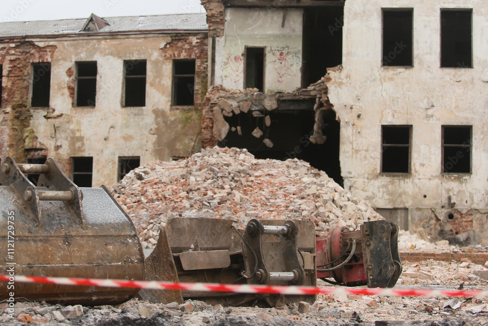 A building being demolished, surrounded by broken bricks and ...