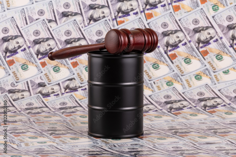 Iron oil barrel and judge's gavel on a flan of 100 US dollar bills ...