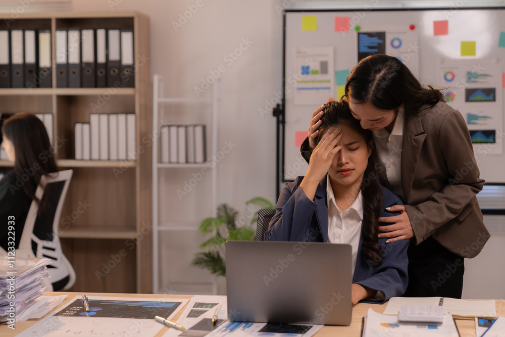 Asian businesswoman comforting her stressed colleague by gently ...
