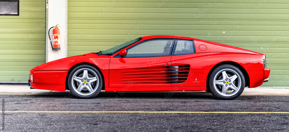 Red Ferrari 512 sports car on the race track. Fast luxury classic car ...