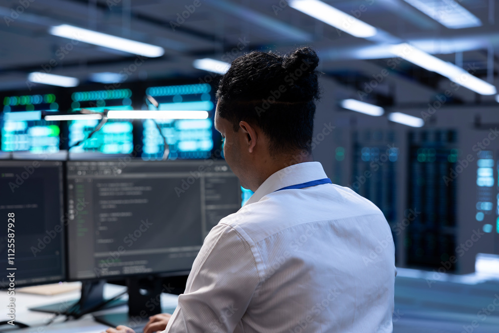 Admin in data center using diagnostic tools and system monitoring software on computer to ...