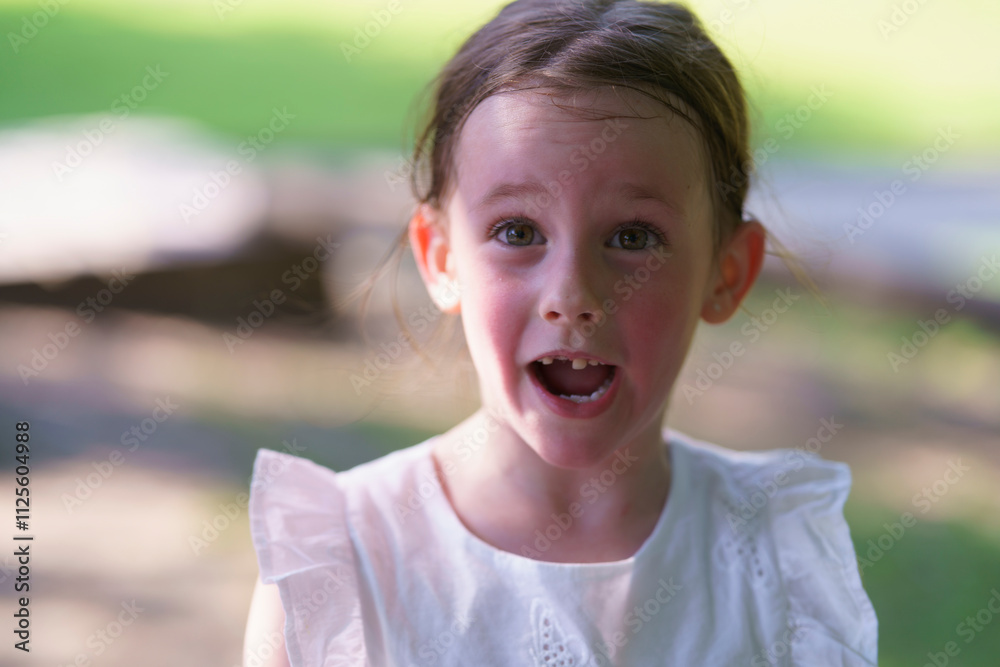 Little cute girl without front teeth on playground in summer in park ...