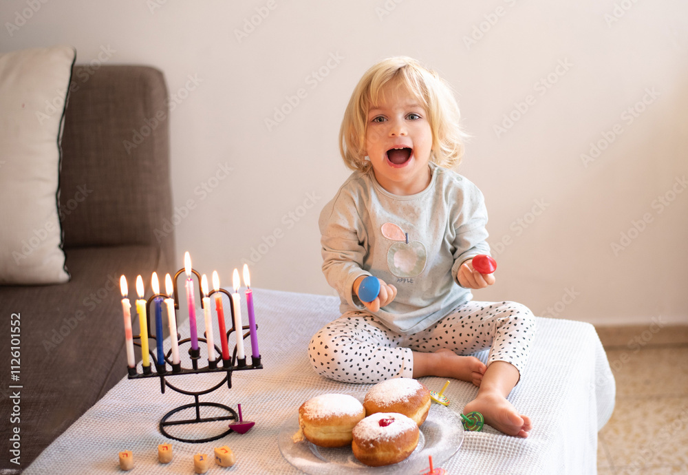 Happy blond baby sit with donut and celebrate Hanuka with Hanukkah ...