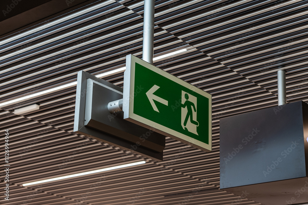 View on emergency exit sign. With running figure and arrow to the left ...