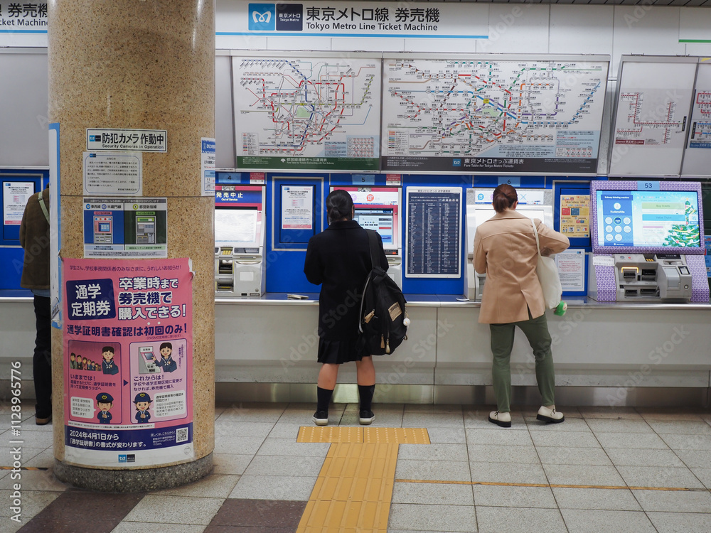 TOKYO, JAPAN - December 7, 2024: People using ticket machines at a ...