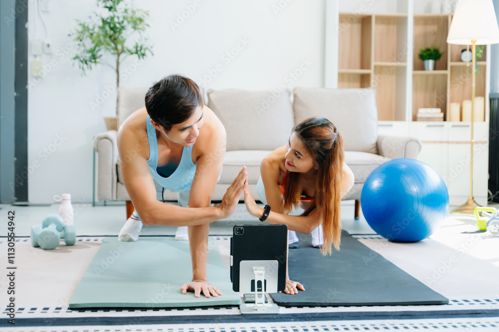 Fitness duo high fiving during an energetic workout session at home ...
