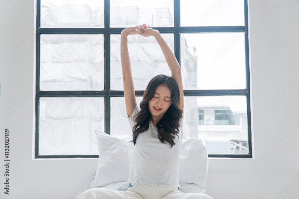 Healthy asian woman waking up relax muscles beside window early in ...