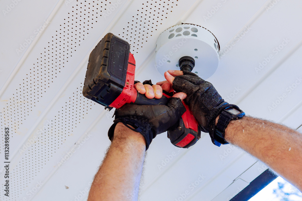 Using cordless drill with hole saw attachment, gloved hand cuts ...
