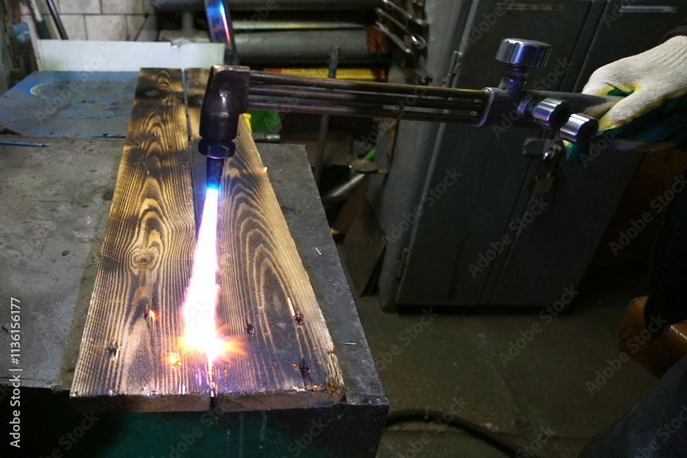 Firing wooden building boards with a gas burner. Wood burning process ...