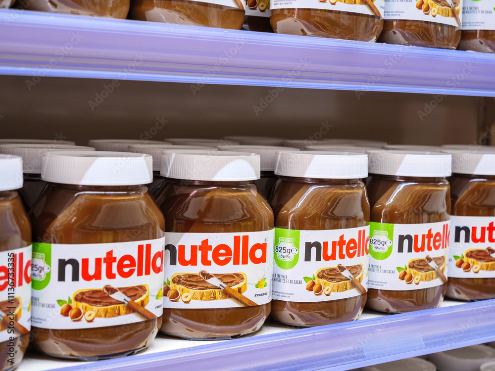 Nutella jars of hazelnut cream in supermaket shelf. Nutella is a brand ...