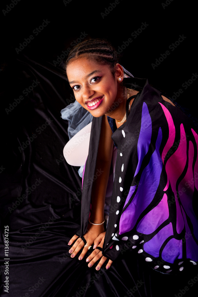 Teenage brunette girl in fetal position dressed in butterfly wings ...