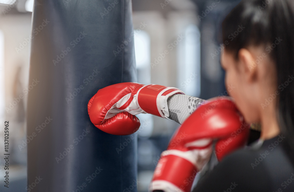 Female boxer in gloves hitting big punching ball during self defence ...