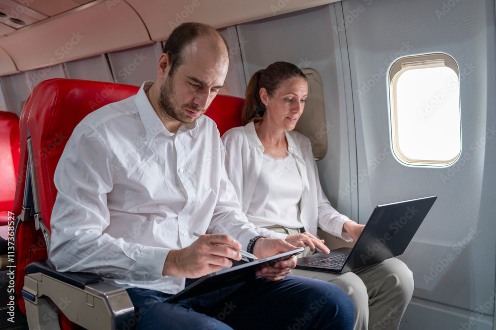 Tourist airplane cabin, engaged in a discussion productive conversation looking at the laptop ...