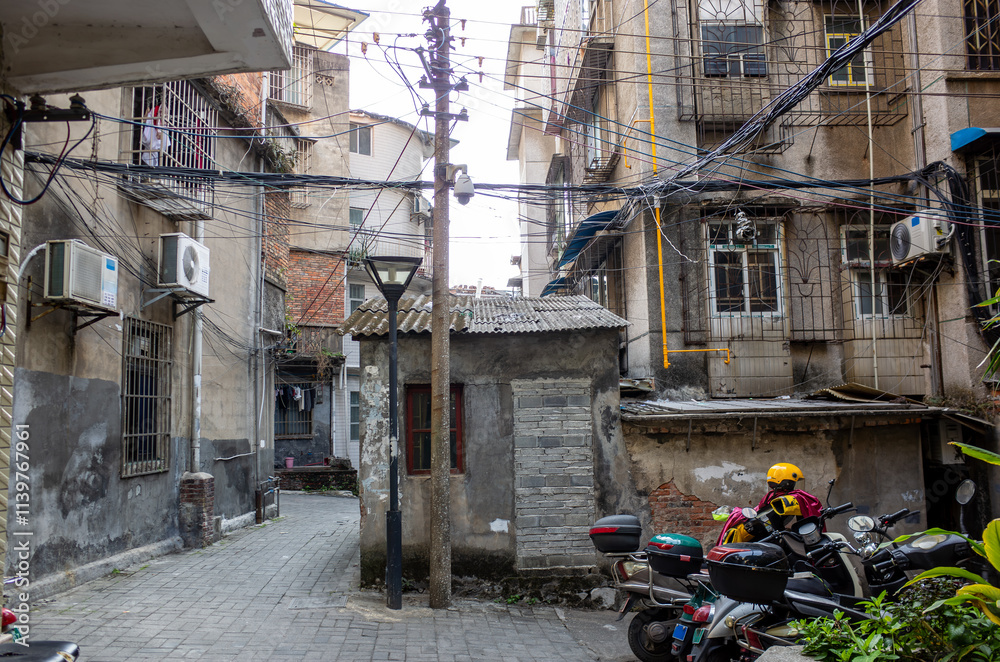 a crowded, urban alleyway in a low-income neighborhood in Liuzhou ...