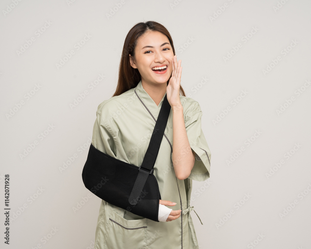 Happy young asian woman broken arm on isolated background. Asian female put on plaster bandage ...
