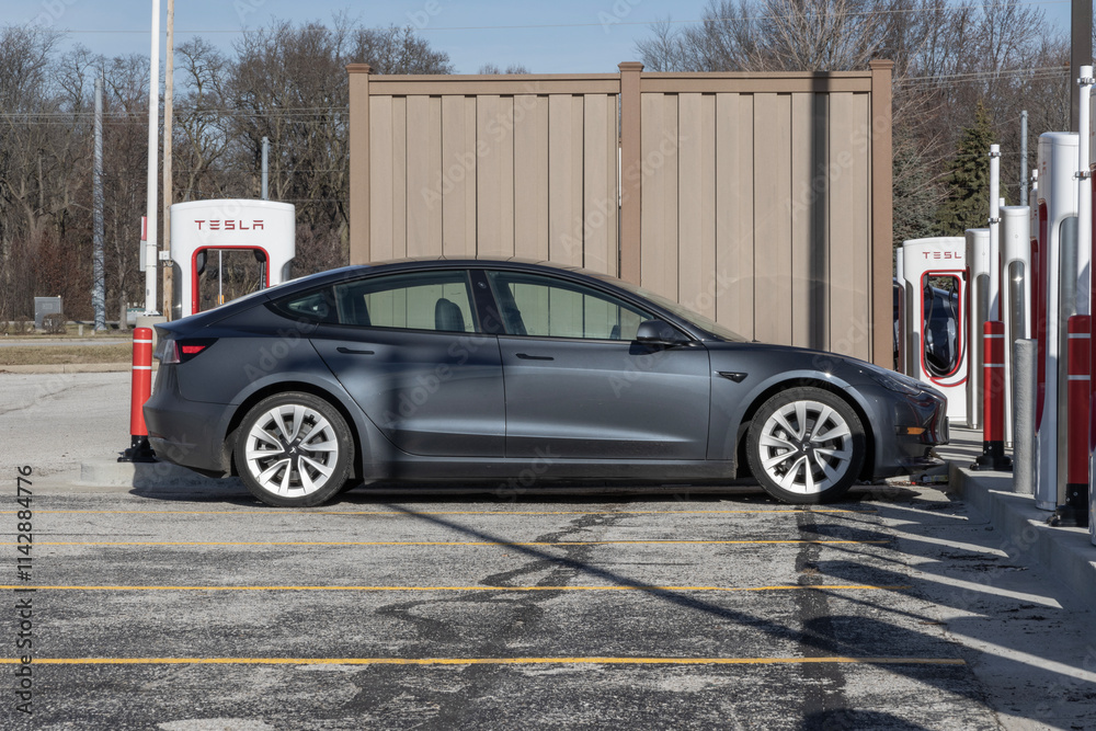 Tesla EV electric vehicle at a Supercharger. Tesla products include ...
