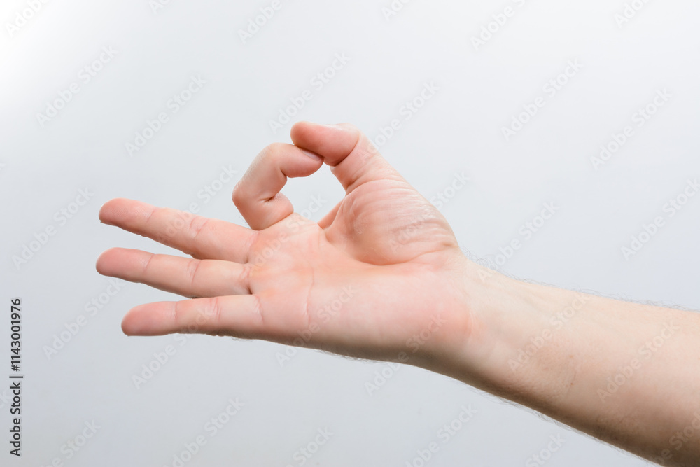 Close-up of a hand forming the 'okay' gesture with thumb and index ...