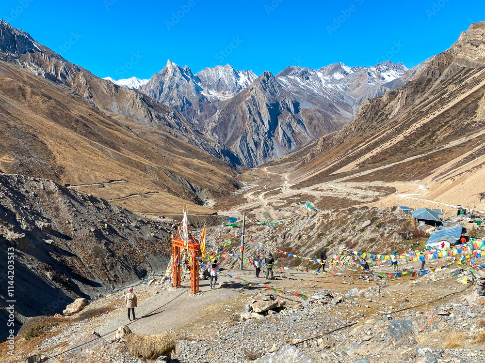Sacred gate with flags and temple bell on the road leading to Om Parvat ...