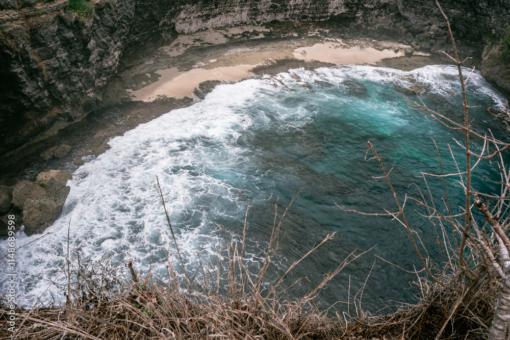 The shoreline located within the circle of a coastal cliff, this beach ...
