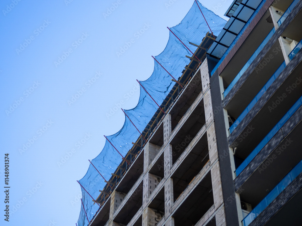 Construction nets on an unfinished building. Construction industry ...
