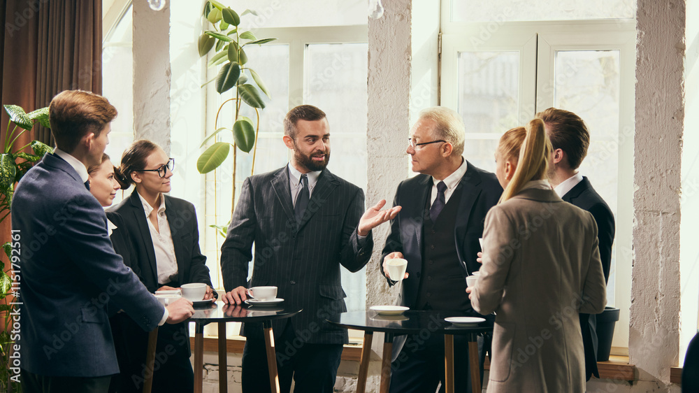 Group of young colleagues in formal wear talking with senior ...
