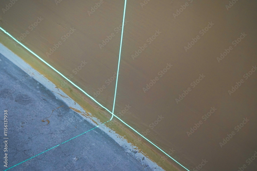 The green laser level projects dual overlapping lines on the floor ...
