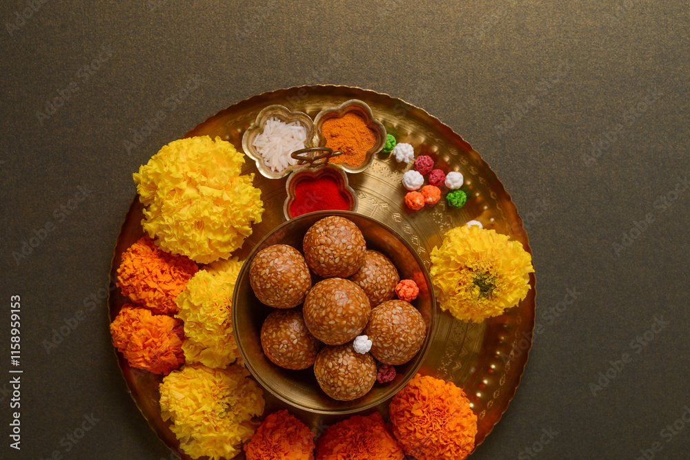 A puja thali for Makar Sankranti festival consists of Tilgul, flowers ...