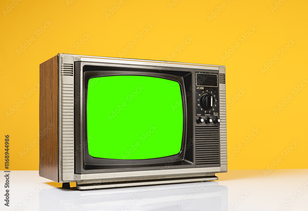 Old retro TV with chroma key green screen on white table with on yellow ...
