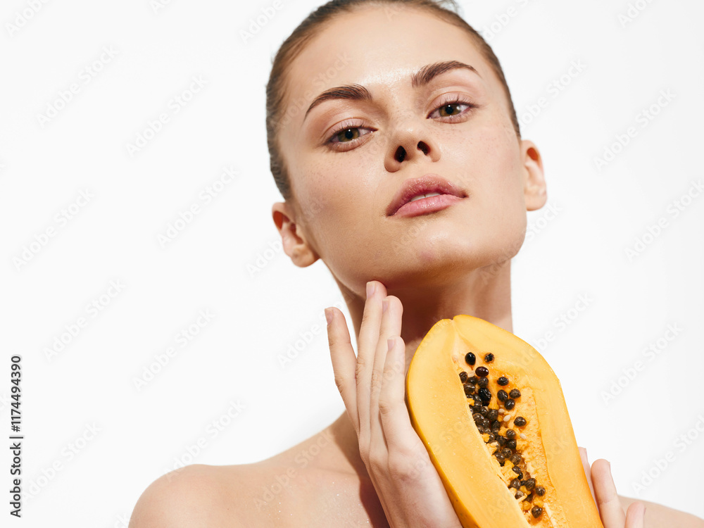 Beautiful young woman applying natural papaya facial mask treatment ...