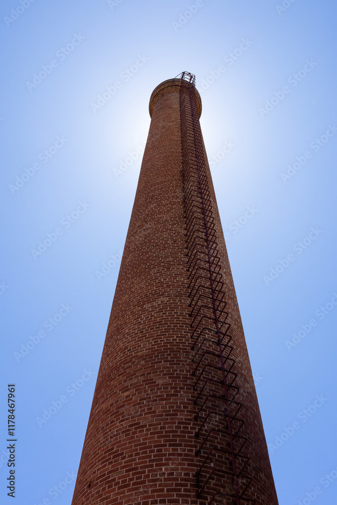 Tall historic brick chimney with a metal ladder of the wood fired pump ...