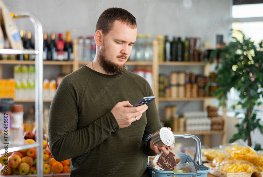 Male shopper scanning QR code on tin can label in grocery department of ...