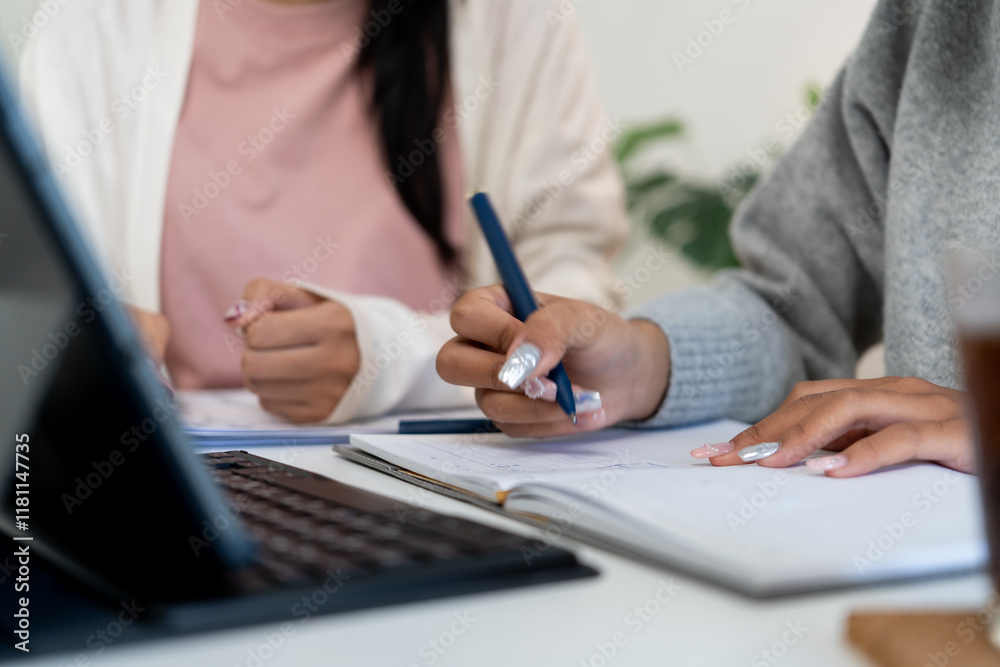 Female higher education student using laptop and studying book in home ...