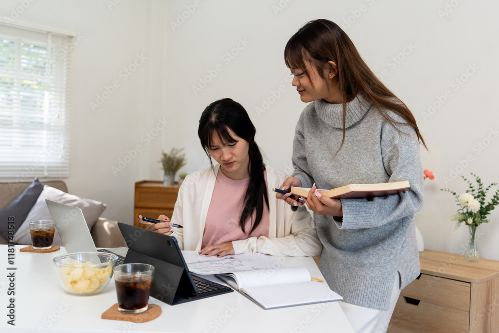 Female higher education student using laptop and studying book in home, Online learning. Stock ...