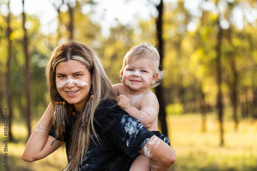 Smiling aboriginal Australian baby with mother in traditional ochre ...