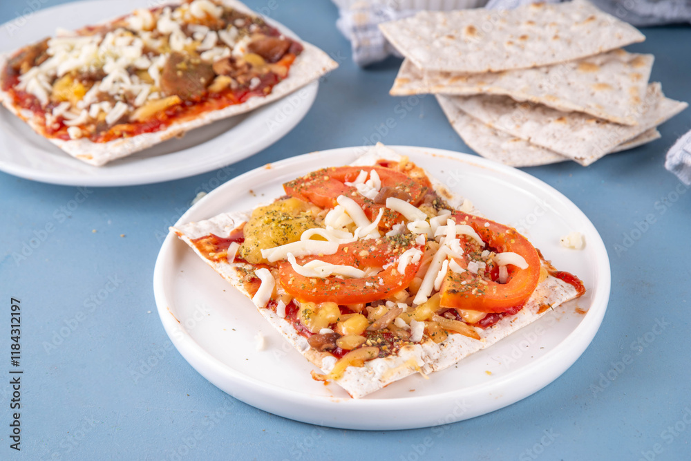 Matzah Pizza on light blue background with ingredients, cheese, tomato ...