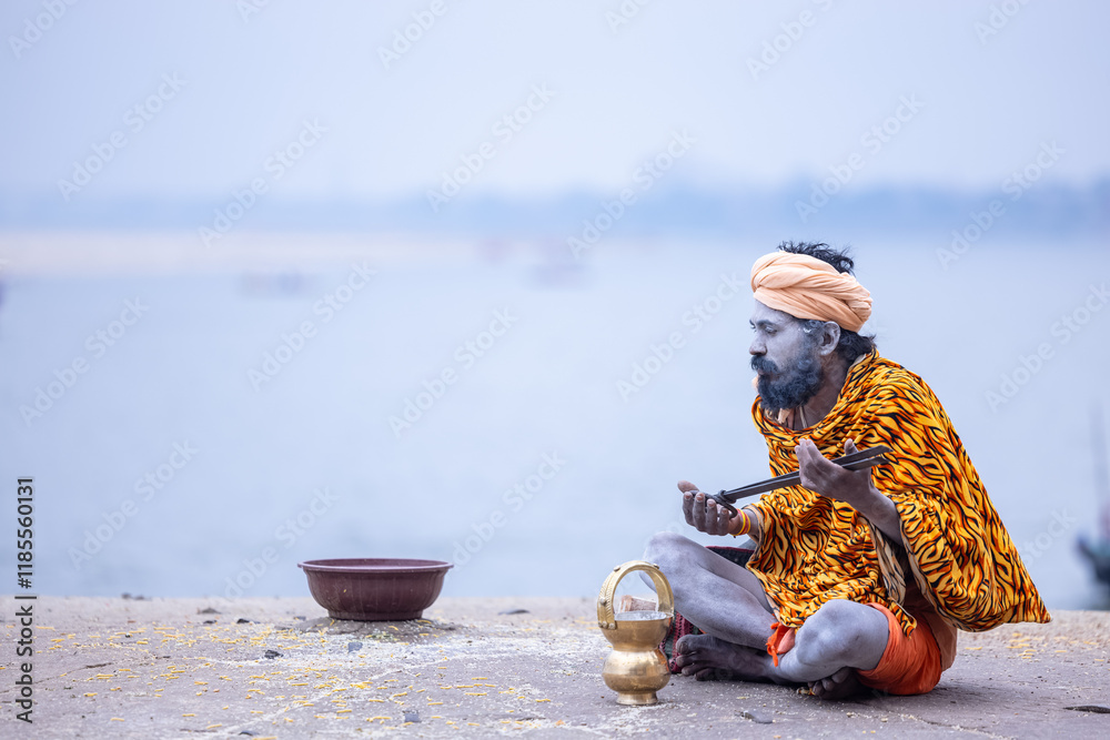 Portrait of an holy naga sadhu baba sitting on ghats near river ganga ...