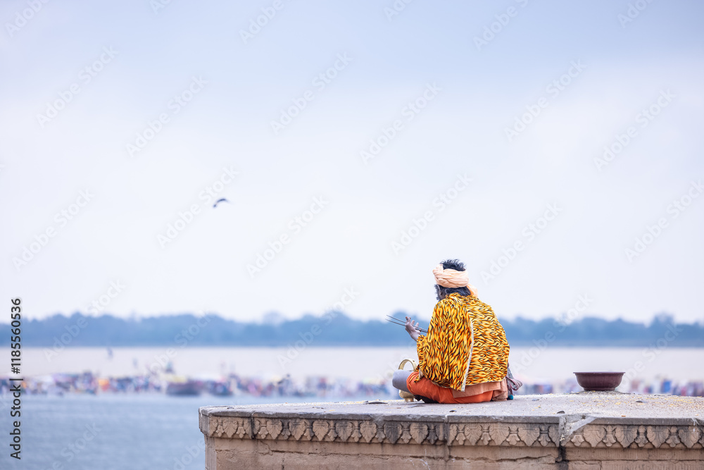 Portrait of an holy naga sadhu baba sitting on ghats near river ganga ...