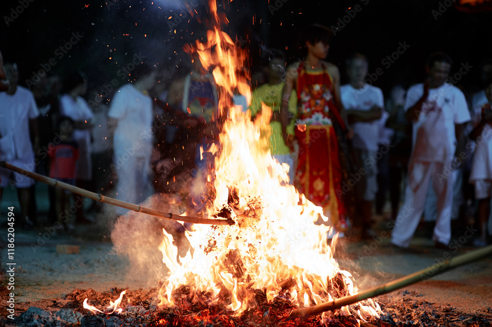 A group of people participating in a traditional fire-walking ceremony ...