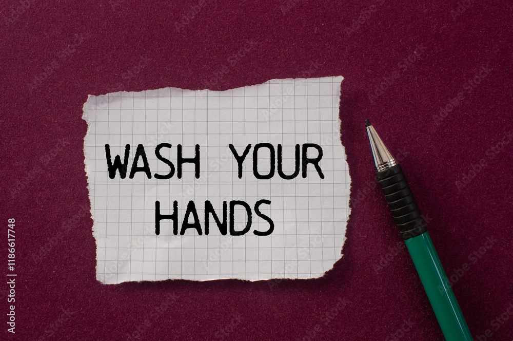 Wash your hands message written on ripped torn paper piece with purple ...