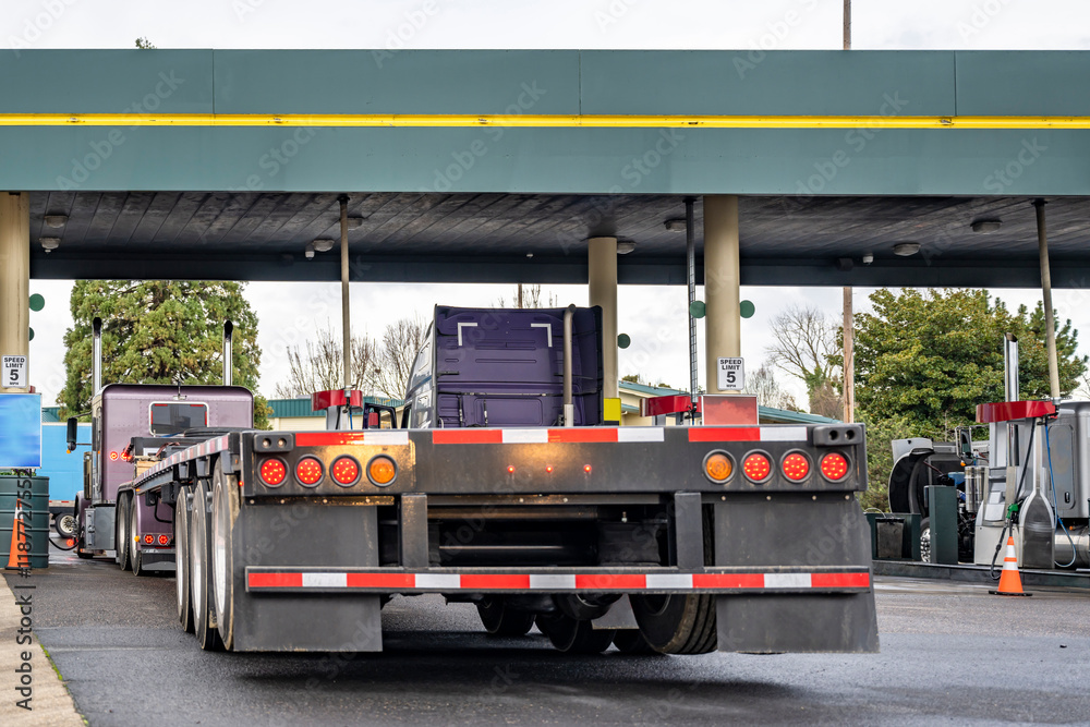 Purple classic big rig semi truck with empty flat bed semi trailer ...