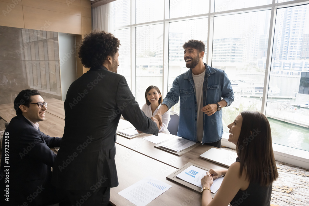 Diverse business partners shaking hands during meeting in modern office ...