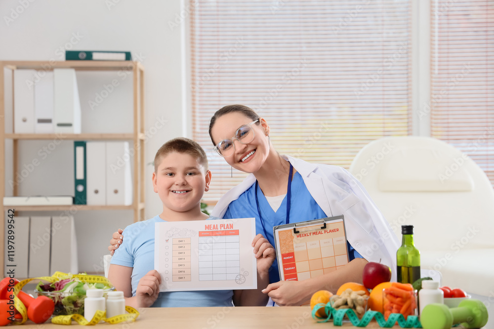 Overweight boy with meal plan and nutritionist at table in clinic. Diet ...