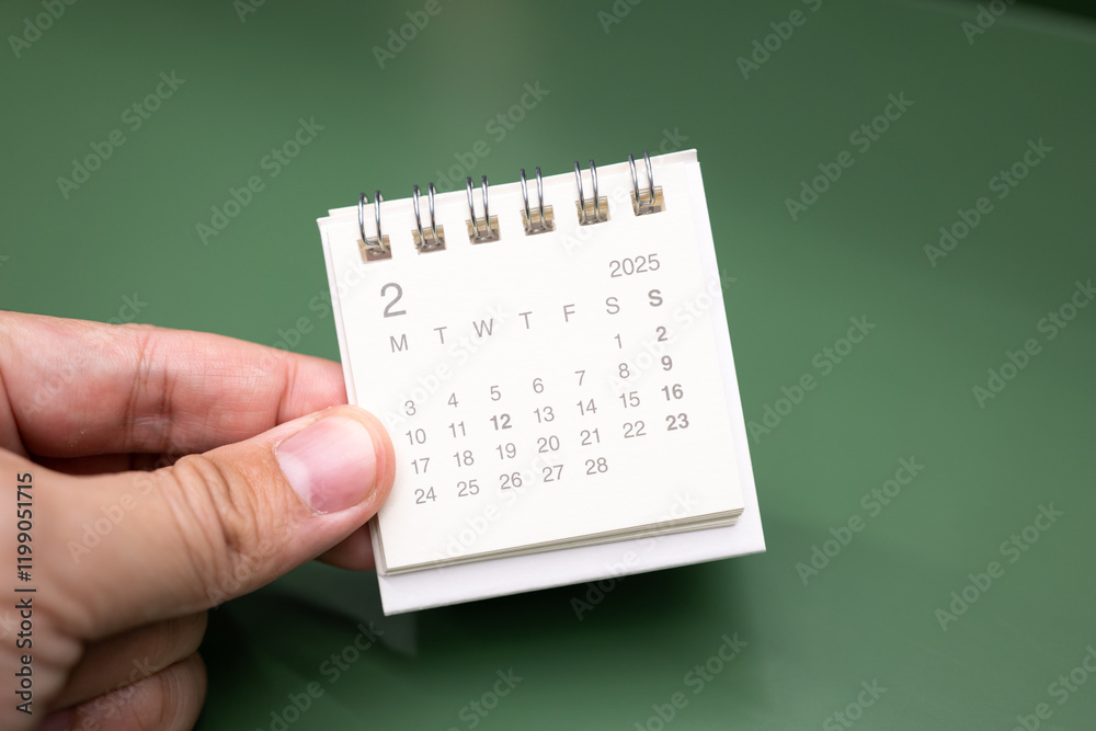 Hand holding mini calendar for 2025 FEBRUARY background. Calendar ...
