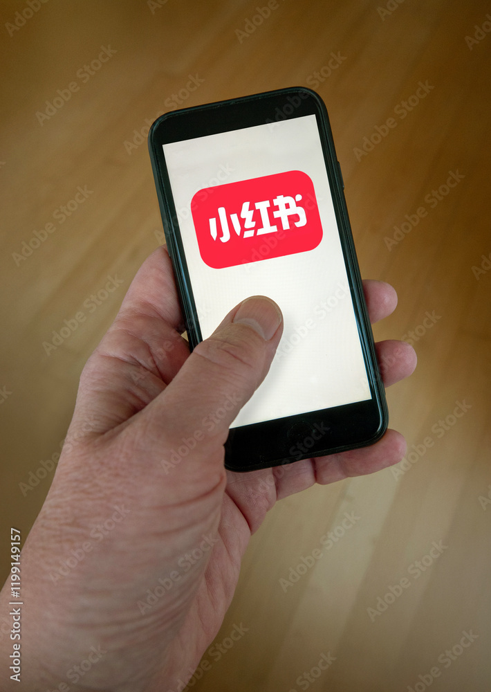 Rednote app on smartphone screen held in hand. Red Note is a Chinese ...