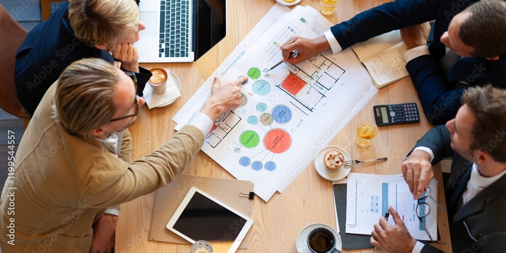 Business meeting with diverse team analyzing charts and plans ...